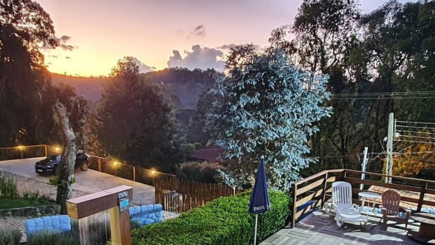 Um quintal com piscina, deck de madeira e uma cascata.
