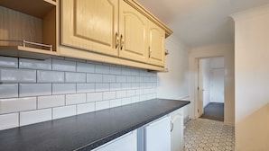 Cozinha com armários de madeira, bancada preta e backsplash de azulejos brancos.