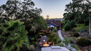 Uma casa com lareira, área de estar externa e um jardim.