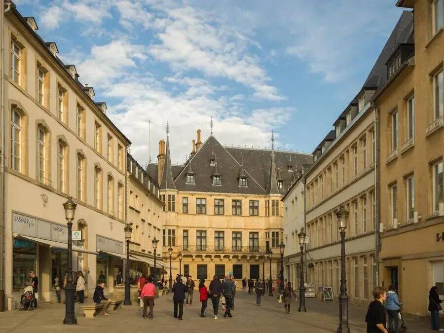 Um edifício histórico com um pátio central, rodeado por lojas e cafés.