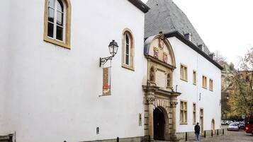 Um edifício branco com uma grande entrada em arco, uma pequena janela e um poste de luz.
