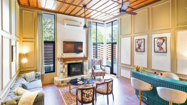 Uma sala de estar aconchegante com lareira, assentos confortáveis e vista para o exterior.