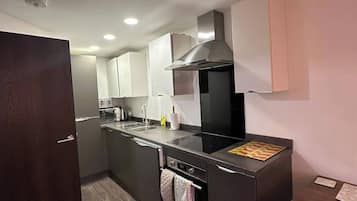 Uma cozinha moderna com ilha central, forno embutido e eletrodomésticos de aço inoxidável.