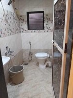 Casa de banho pequena com sanita, lavatório e chuveiro.