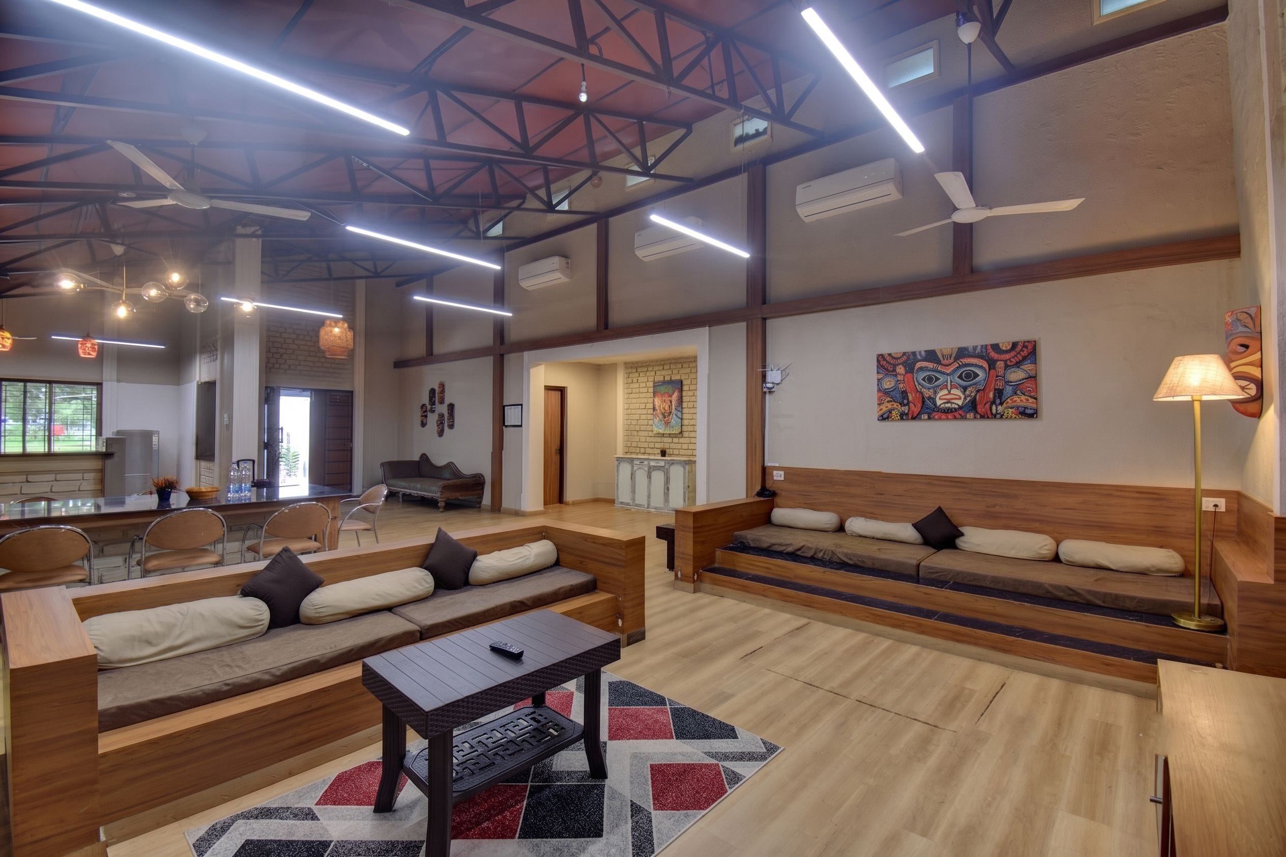 Uma sala de estar ampla com teto alto, mobiliário de madeira e design moderno.