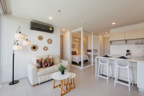 Um apartamento moderno com sala de estar, área de refeições e cozinha.
