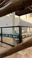 Estrutura de pérgola de madeira com mesa de bilhar e placa indicando Village Comfort Hotel.