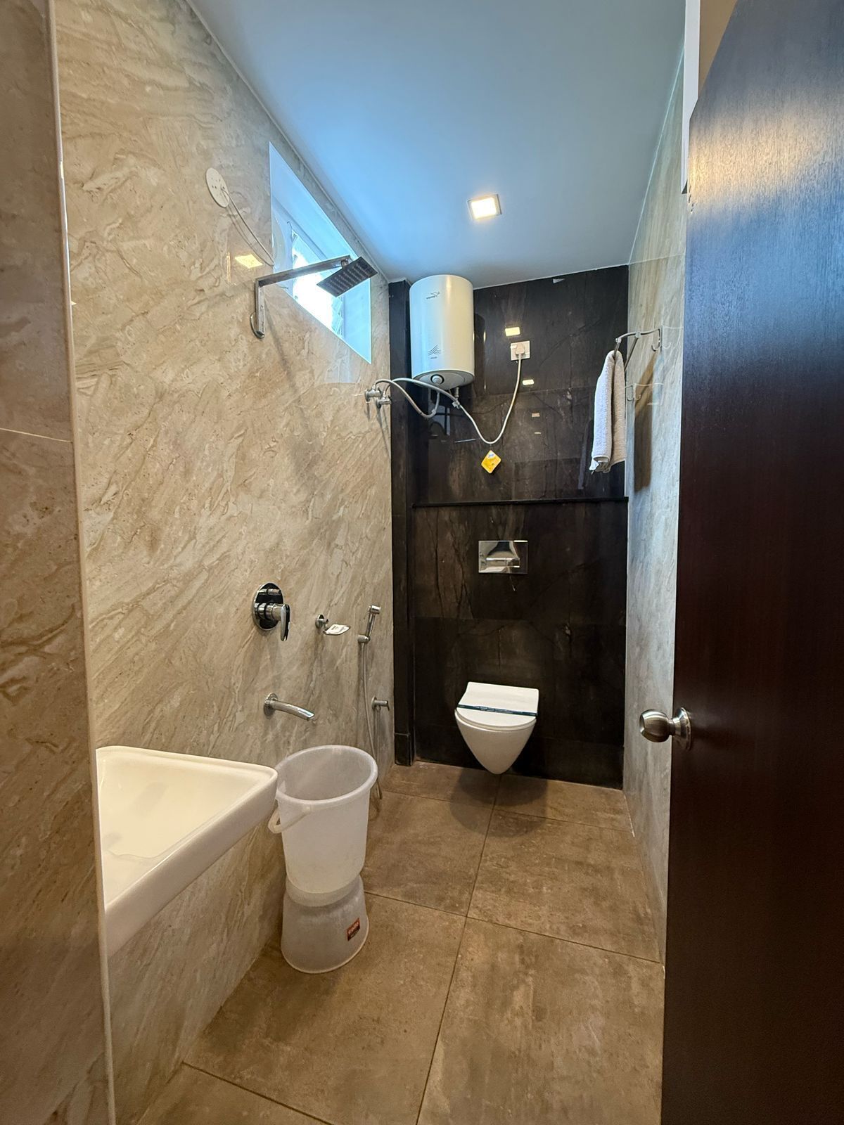 Uma casa de banho moderna com banheira, sanita e chuveiro.