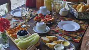 Uma mesa posta com itens de café da manhã, incluindo pão, queijo e ovos.