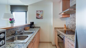 Uma cozinha moderna com bancadas de granito, eletrodomésticos de aço inoxidável e armários de madeira.