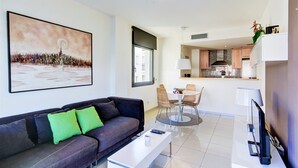 Uma sala de estar moderna com um sofá, mesa de centro e um quadro na parede.