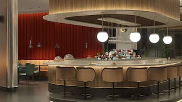 Uma área de bar moderna com balcão curvo, banquetas e luminárias pendentes.