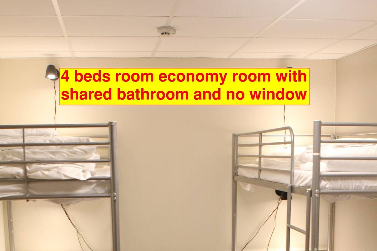 Quarto para 4 pessoas com beliches, banheiro compartilhado e sem janelas.