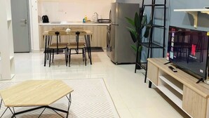 Uma cozinha moderna com área de refeições, TV e uma planta.