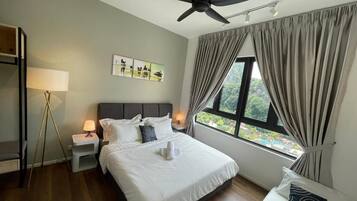 Quarto de hotel com cama, luminárias de cabeceira, ventoinha no teto, janela com cortinas e obras de arte na parede.