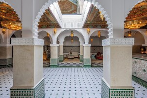 Um interior com arcos, piso estampado e luminárias pendentes.