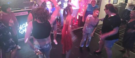 Um espaço interno lotado com palco e cabine para DJ.