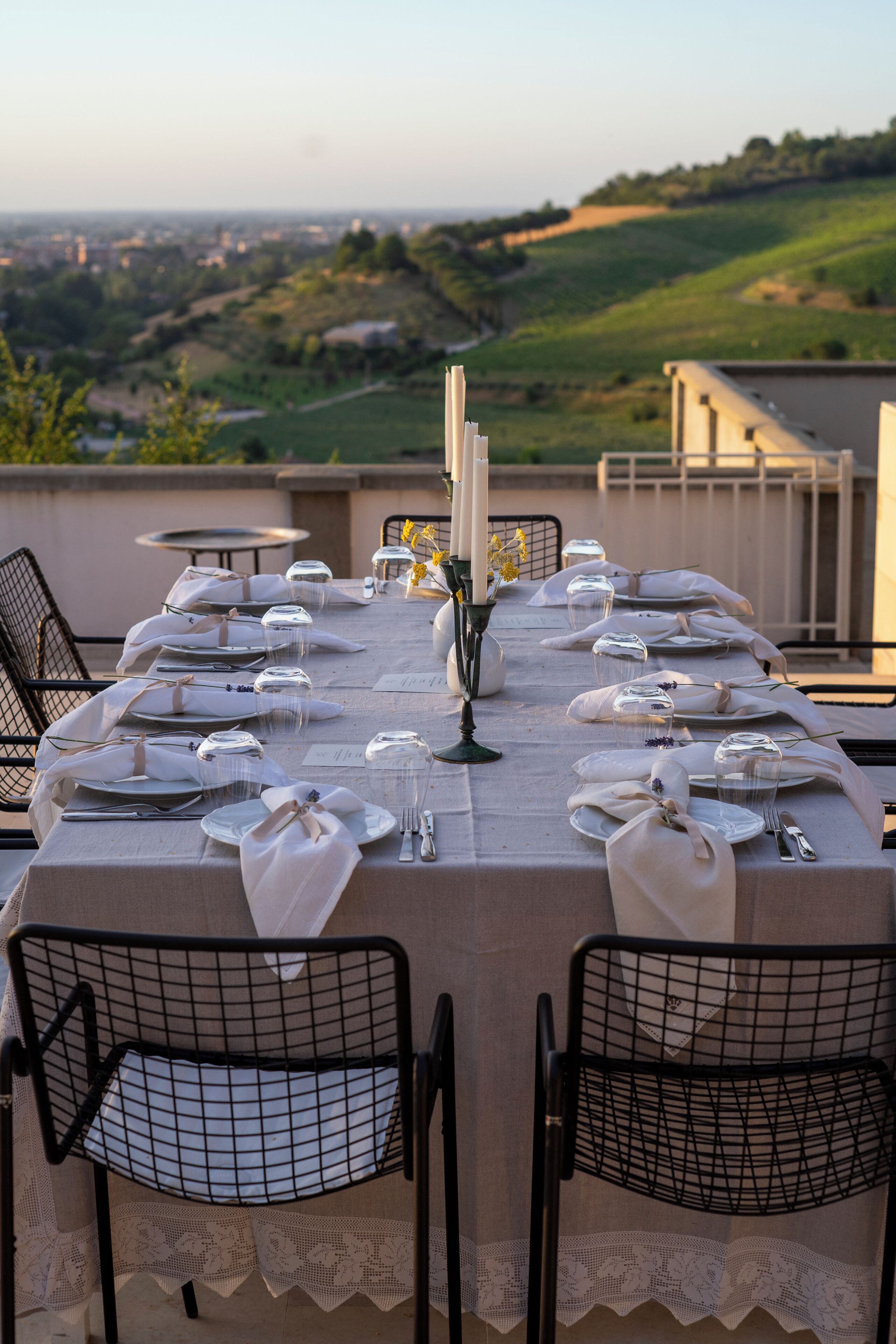 Uma mesa posta para refeição, com vista para o campo.