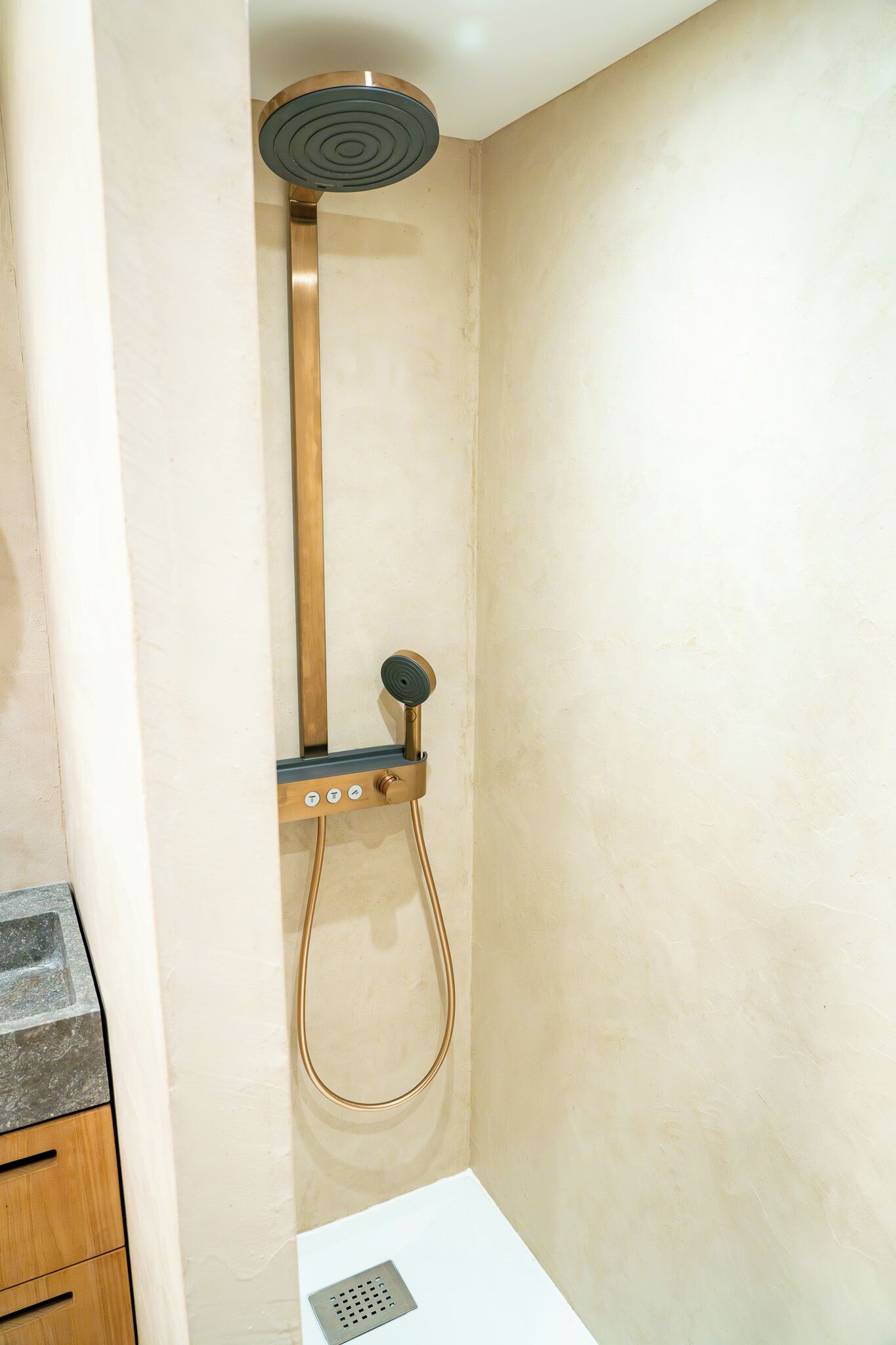 Chuveiro moderno com painel de controle vertical e chuveiro manual.