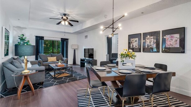 Uma sala de estar moderna com sofá, mesa de centro e área de jantar com mesa posta para quatro pessoas.