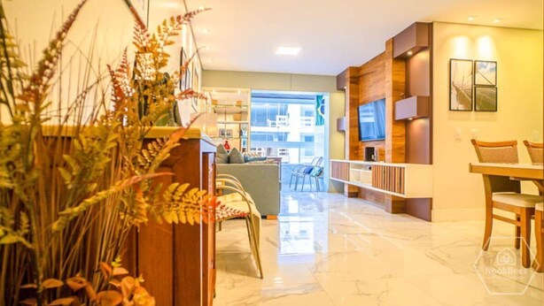 Uma sala de estar moderna com área de jantar, televisão e vista para a cidade.
