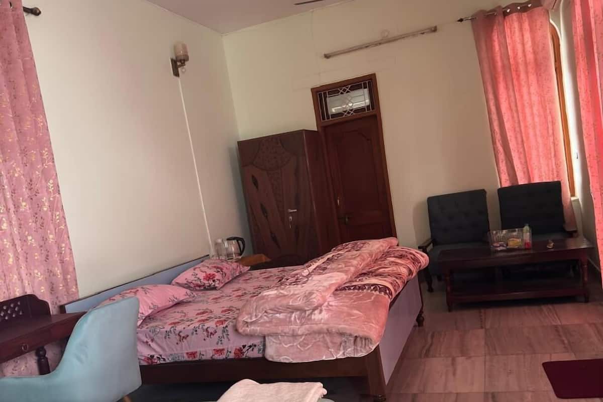 Quarto com cama, escrivaninha, cadeira, guarda-roupa e ventilador de teto.