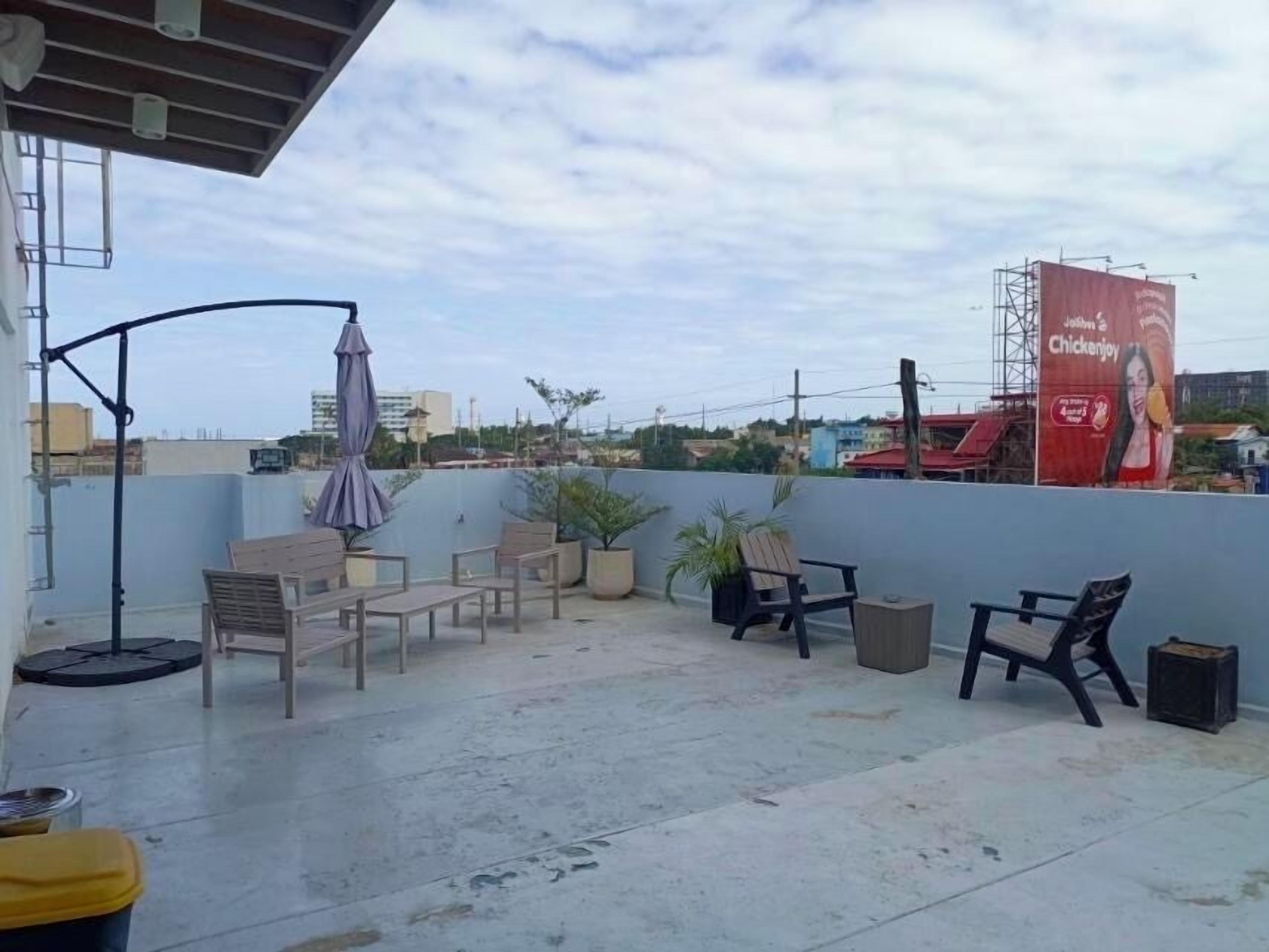 Um pátio externo com assentos, piscina e vista para a cidade.