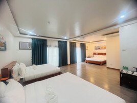 Quarto de hotel com duas camas, uma cabeceira de madeira, uma mesinha com produtos de higiene e um quadro na parede.