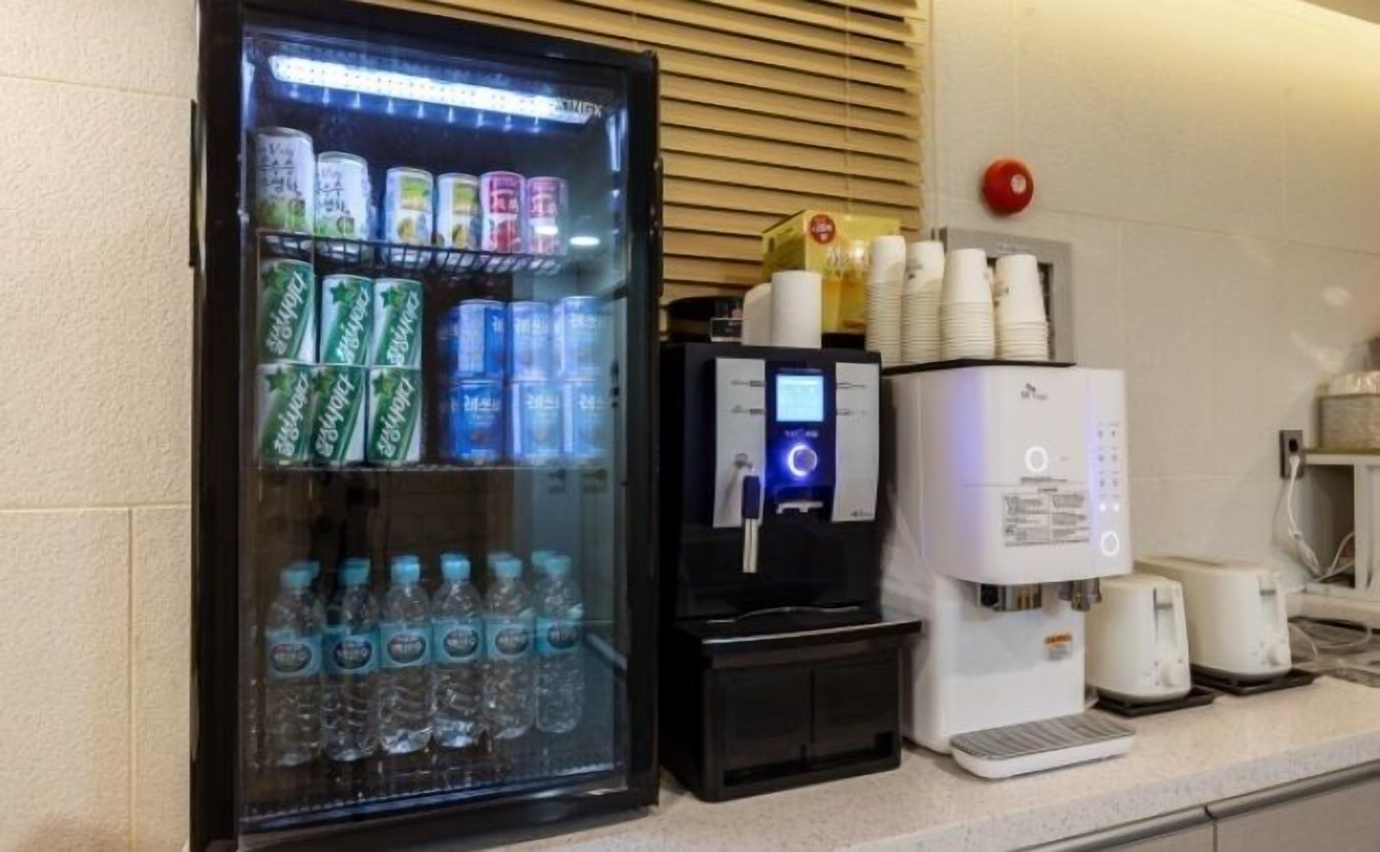 Máquina de vendas com diversas bebidas e uma máquina de café.