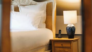 Quarto de hotel com cama, mesa de cabeceira, abajur e telefone.