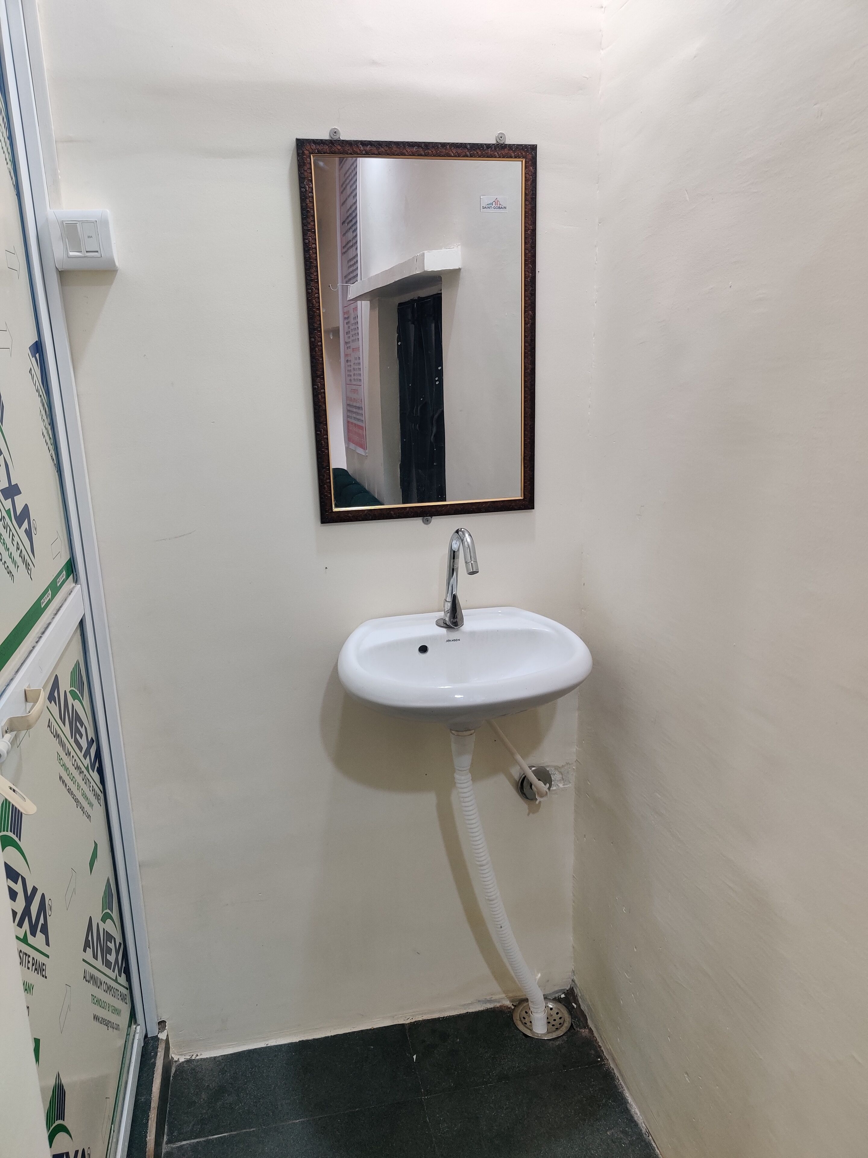 Casa de banho com uma sanita branca, um espelho e uma cortina de chuveiro.