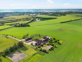Um amplo campo aberto com uma casa e uma piscina.