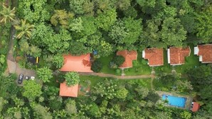Vista aérea de um bairro residencial com casas, piscina e muita vegetação.