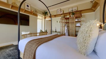 Quarto com cama de dossel, cabeceira de madeira, mesa de cabeceira, espelho e prateleira com objetos decorativos.