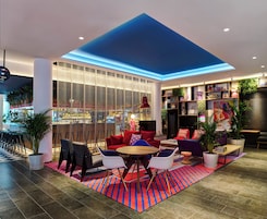 Uma área de lounge moderna com bar, assentos e uma grande janela com vista para o bar.