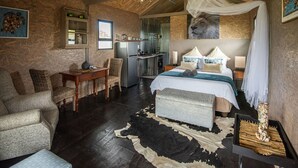 Um quarto aconchegante com uma cama, uma mesa de jantar e uma cozinha.