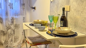 Mesa de jantar com tigelas, copos e uma garrafa de vinho.