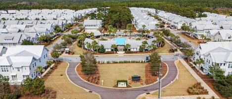 Um bairro residencial com várias casas, uma piscina central e um traçado de ruas curvas.