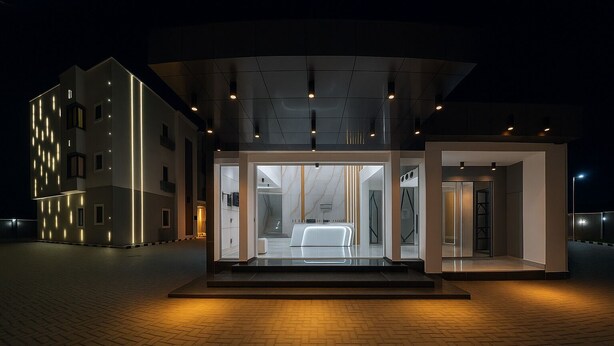 Um edifício moderno com entrada de vidro, escadaria visível e interior bem iluminado.