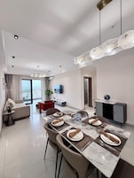 Uma área de jantar moderna com mesa de mármore, cadeiras e vista para a cidade.