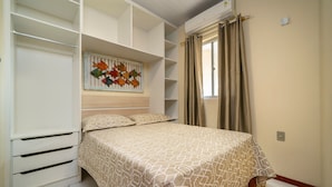 Quarto com cama, guarda-roupa e um enfeite de peixe na parede.