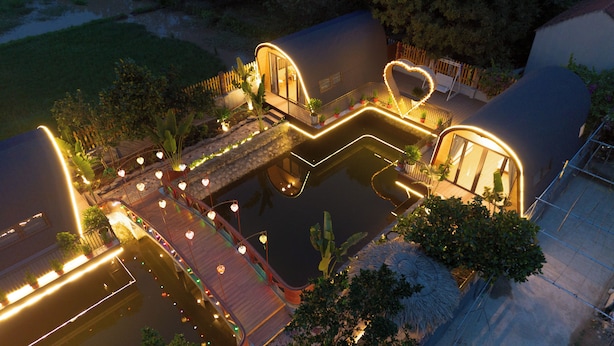 Vista aérea de uma propriedade com piscina, deck e uma instalação de luz em formato de coração.