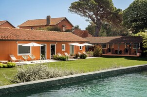 Um imóvel residencial com piscina, área de estar ao ar livre e gramado bem cuidado.