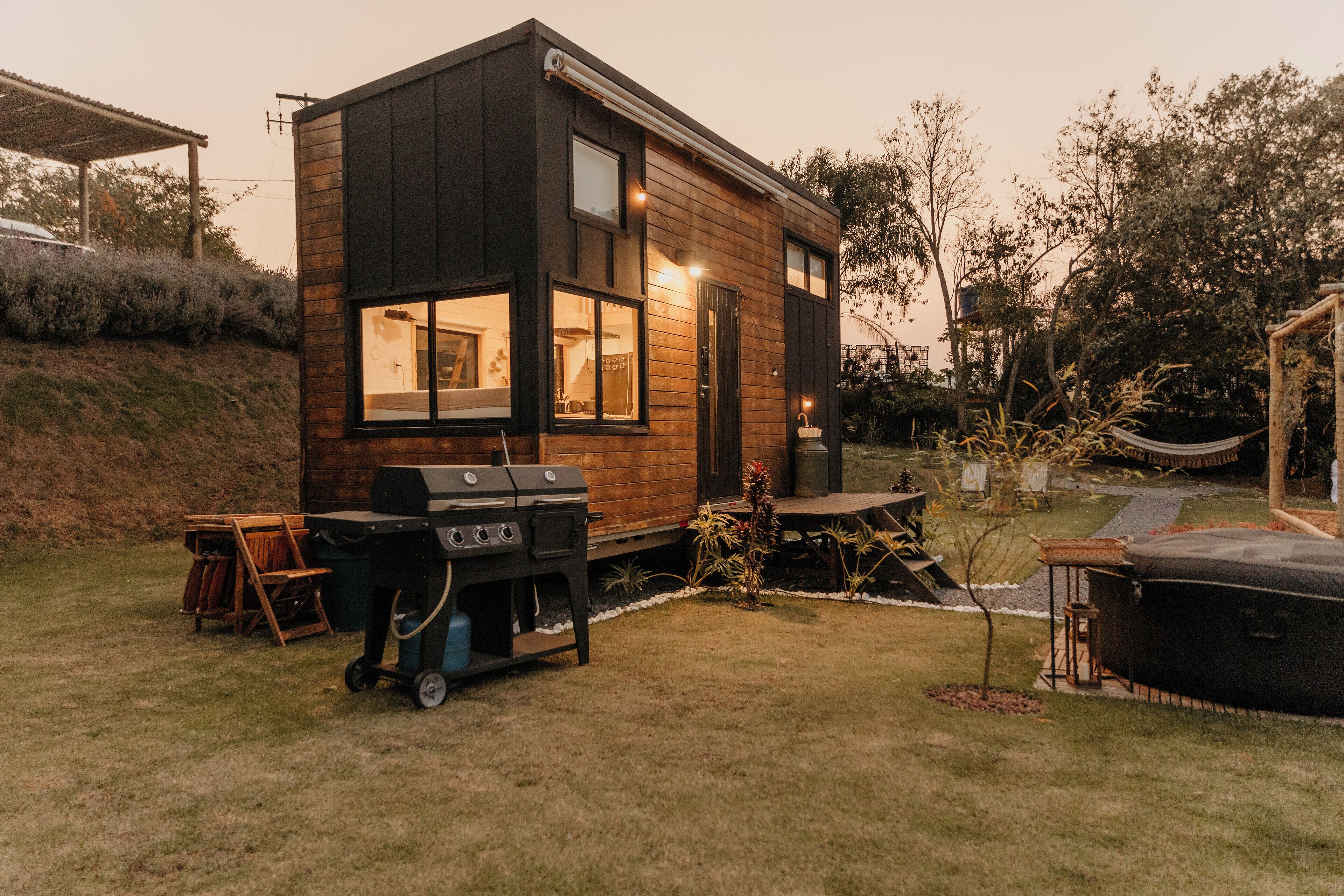 Uma casa moderna com um deck amplo, churrasqueira e hidromassagem.