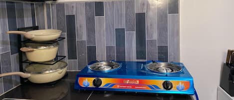 Uma placa de cozinha, uma máquina de lavar louça, utensílios de cozinha