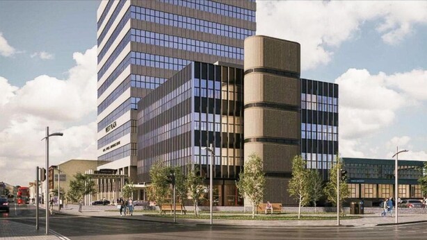 Um edifício moderno de vários andares com fachada de vidro e uma seção cilíndrica singular.