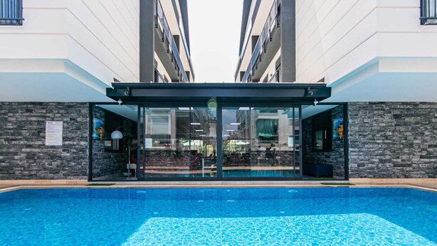 Um edifício moderno com piscina em frente.