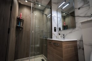 Apartamento Deluxe, 2 quartos | Casa de banho | Um polibã, artigos de higiene pessoal grátis, um secador de cabelo 
