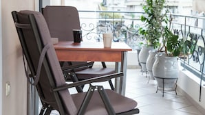 Varanda com mesa, cadeiras e plantas em vasos.