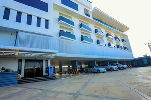 Um hotel moderno com área de estacionamento coberta e vários andares.